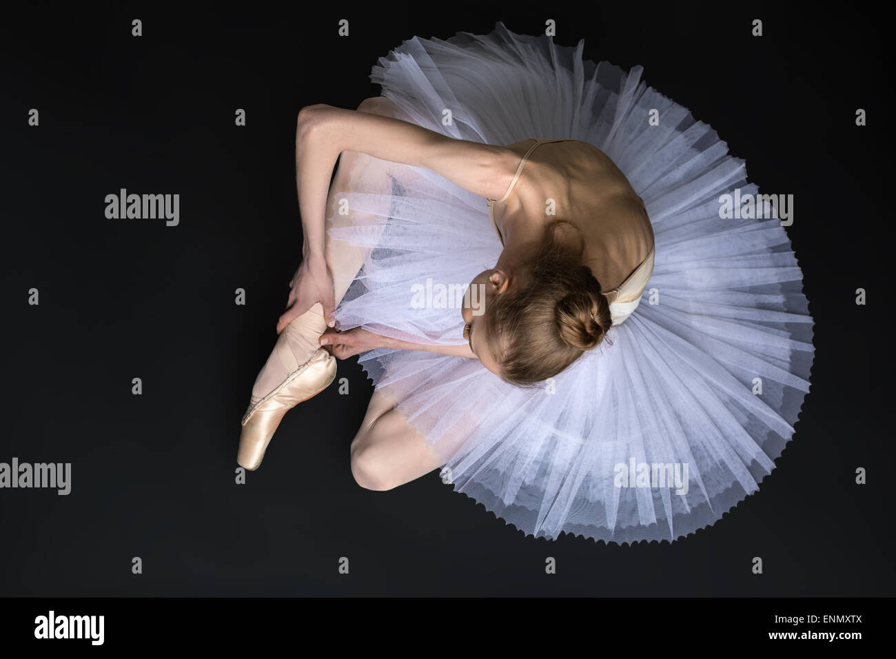 Jeune Ballet danseuse attachant pointe assis sur le plancher Photo ...
