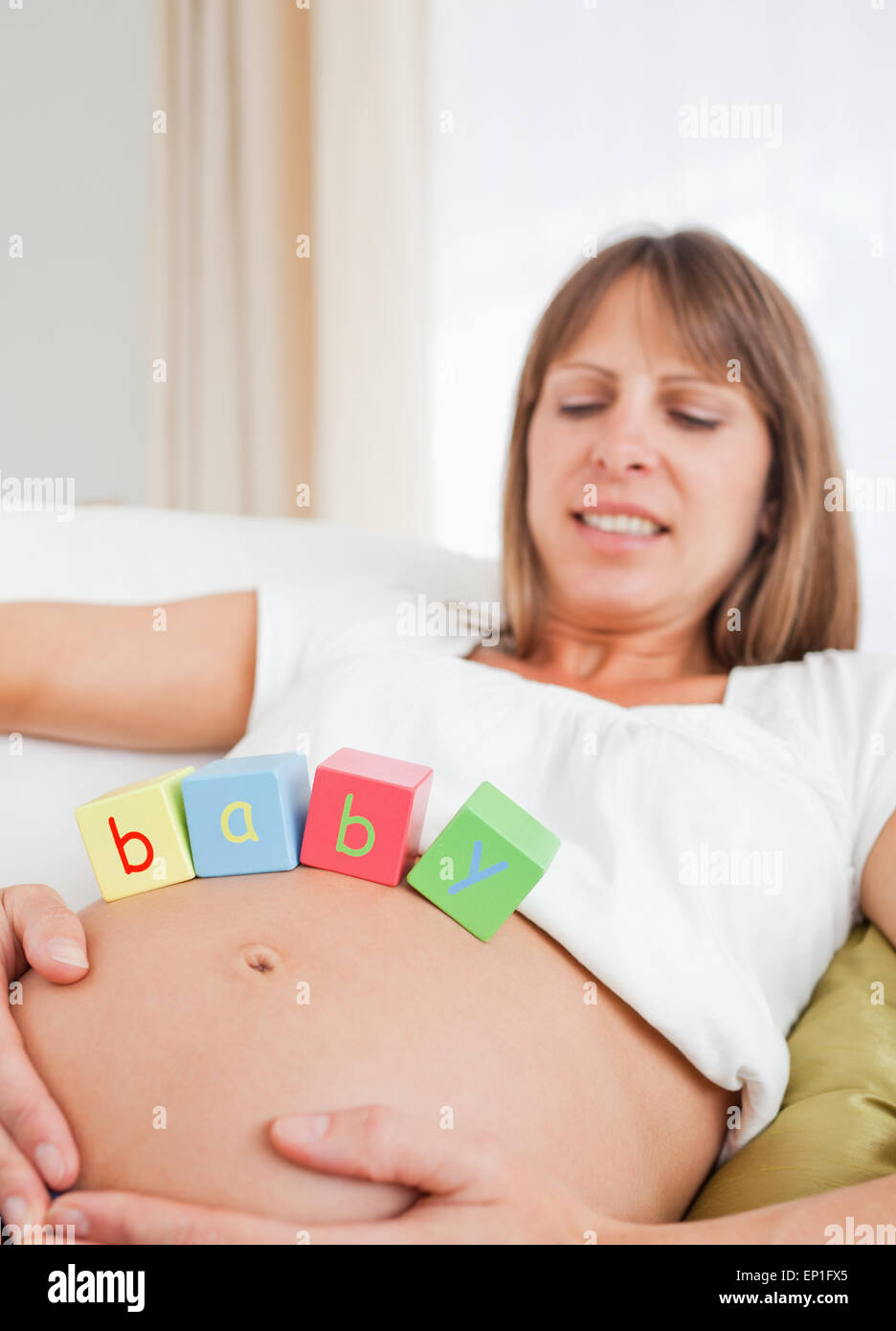Belle femelle enceinte jouant avec des blocs de bois en position ...