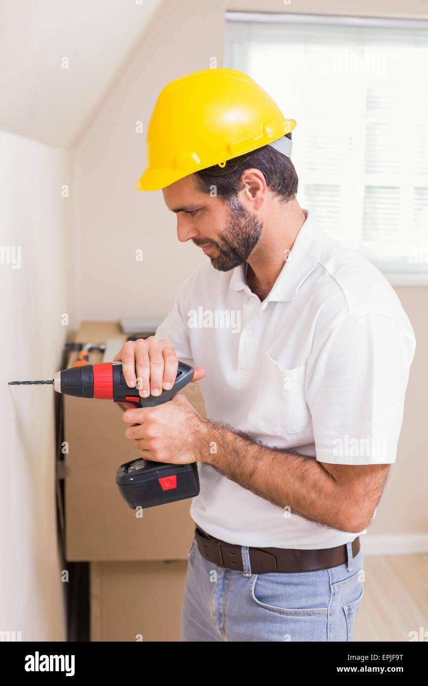 Travailleur de la construction de percer le trou dans le mur Photo ...