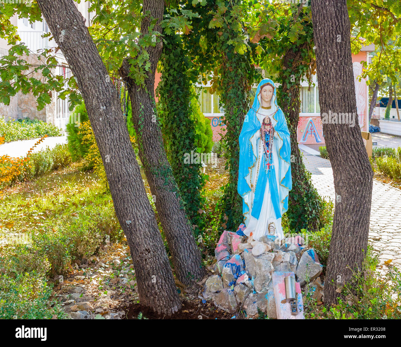 Statue de la Vierge Marie parmi les arbres couverts de lierre. Les ...