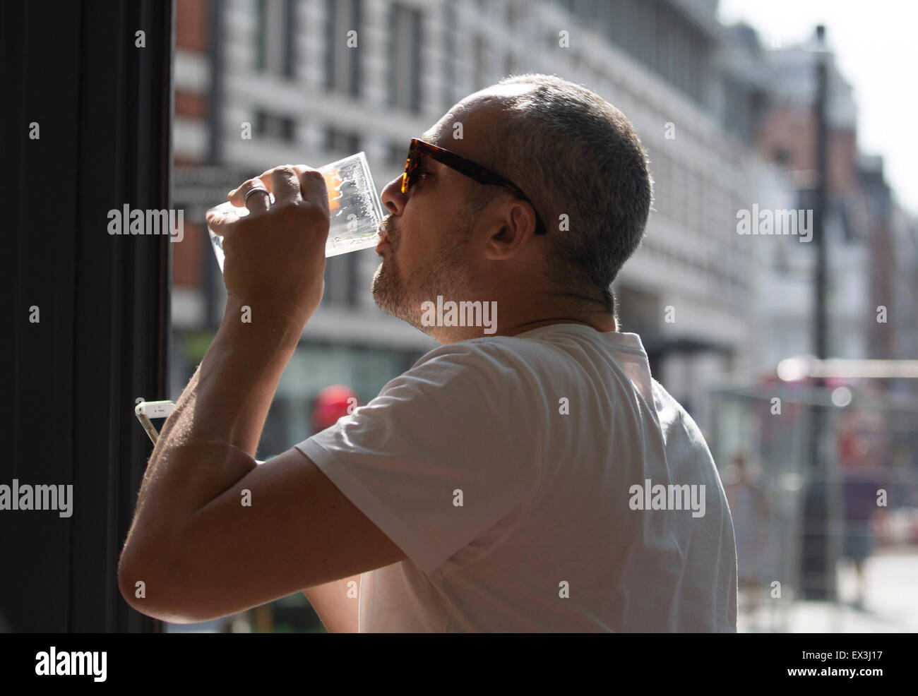 L'homme dans un pub boire une pinte de bière blonde et de contrôler son ...