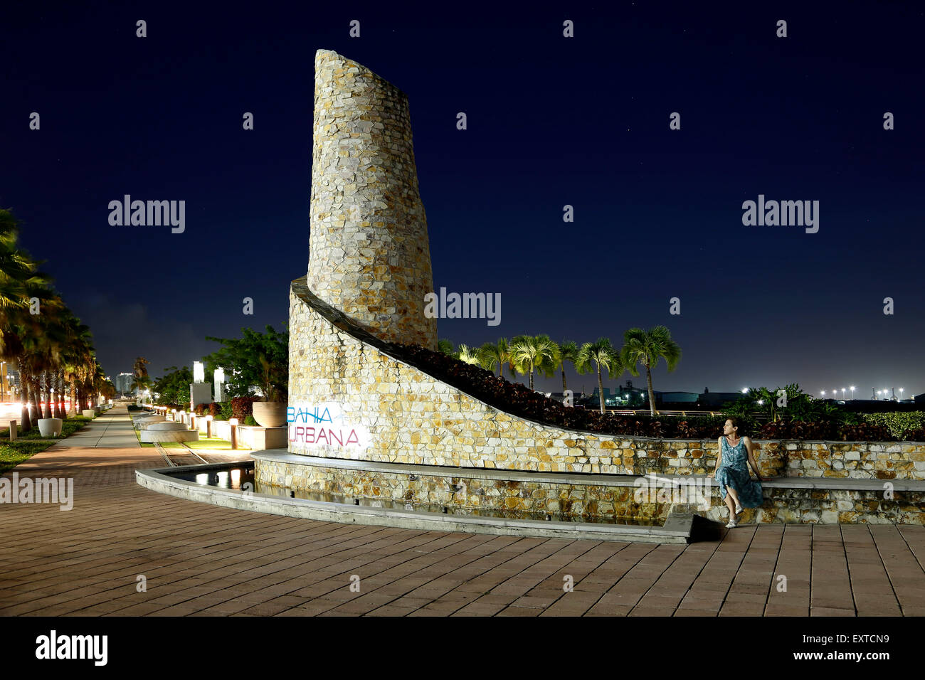 Femme assise à côté de colonne en pierre marquant entrée de Bahia ...