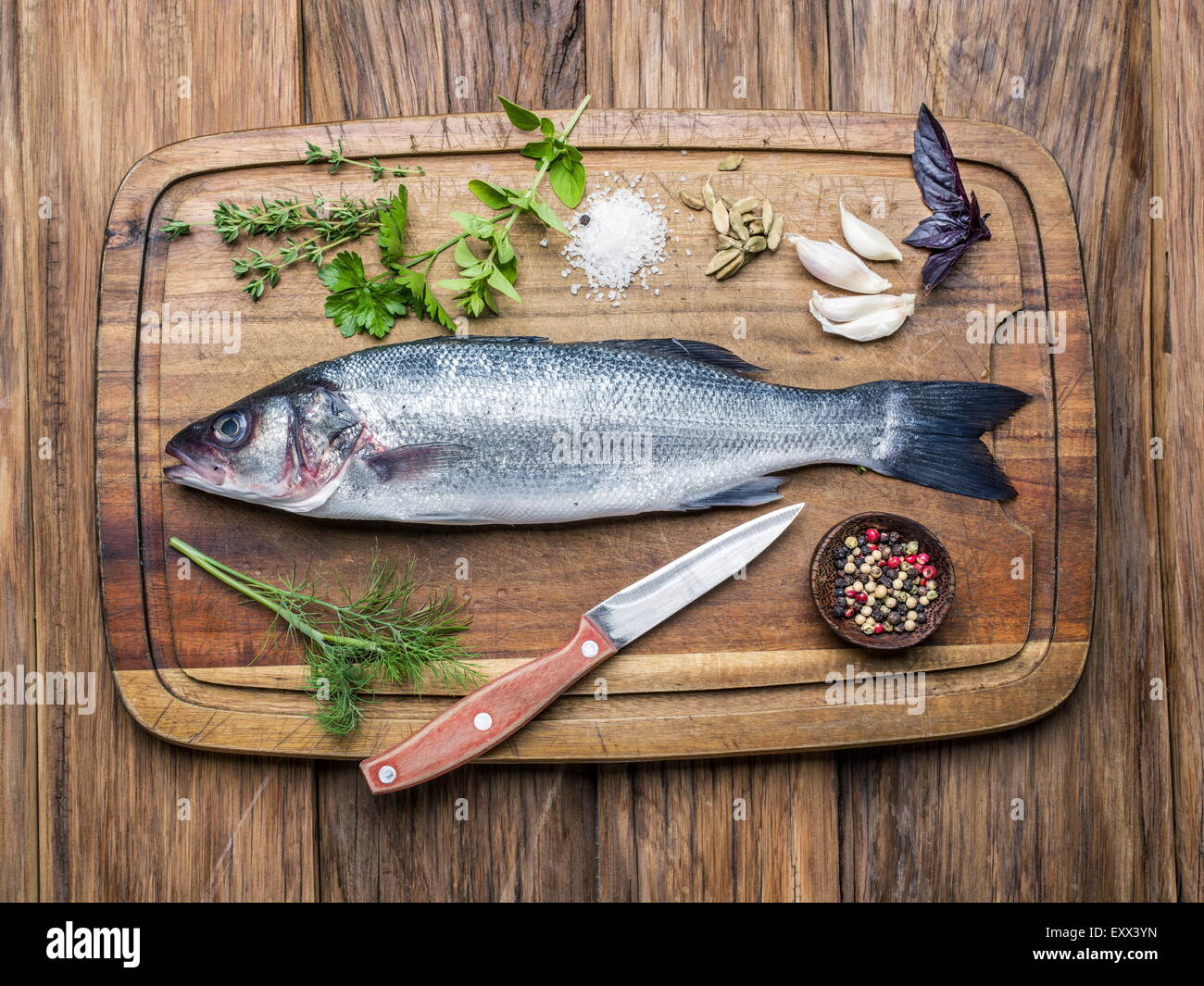 Bar ou Loup - poisson sur une planche en bois avec des épices et fines ...