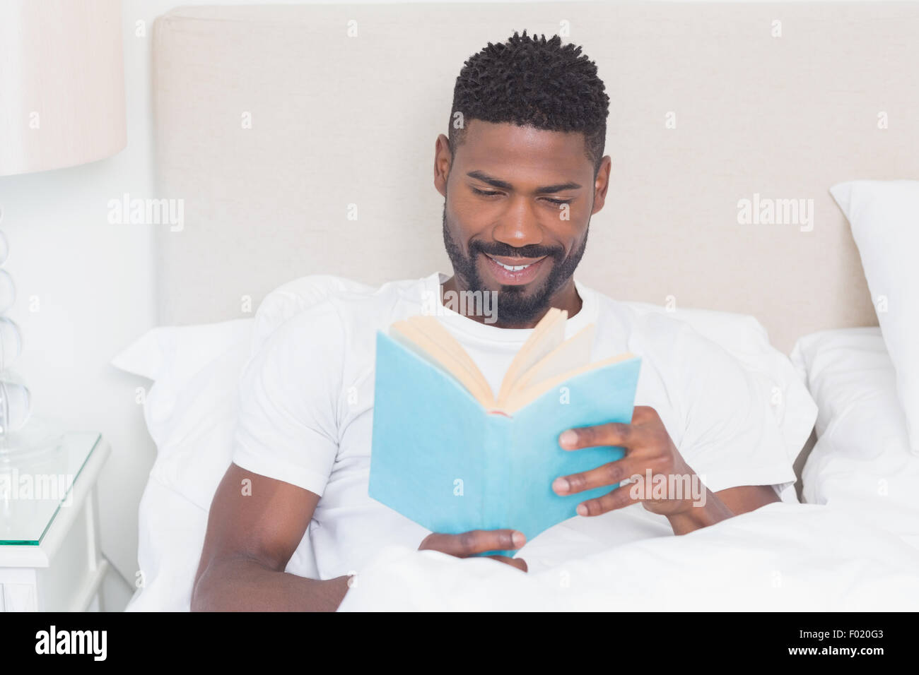 En train de lire au lit Banque de photographies et d’images à haute ...