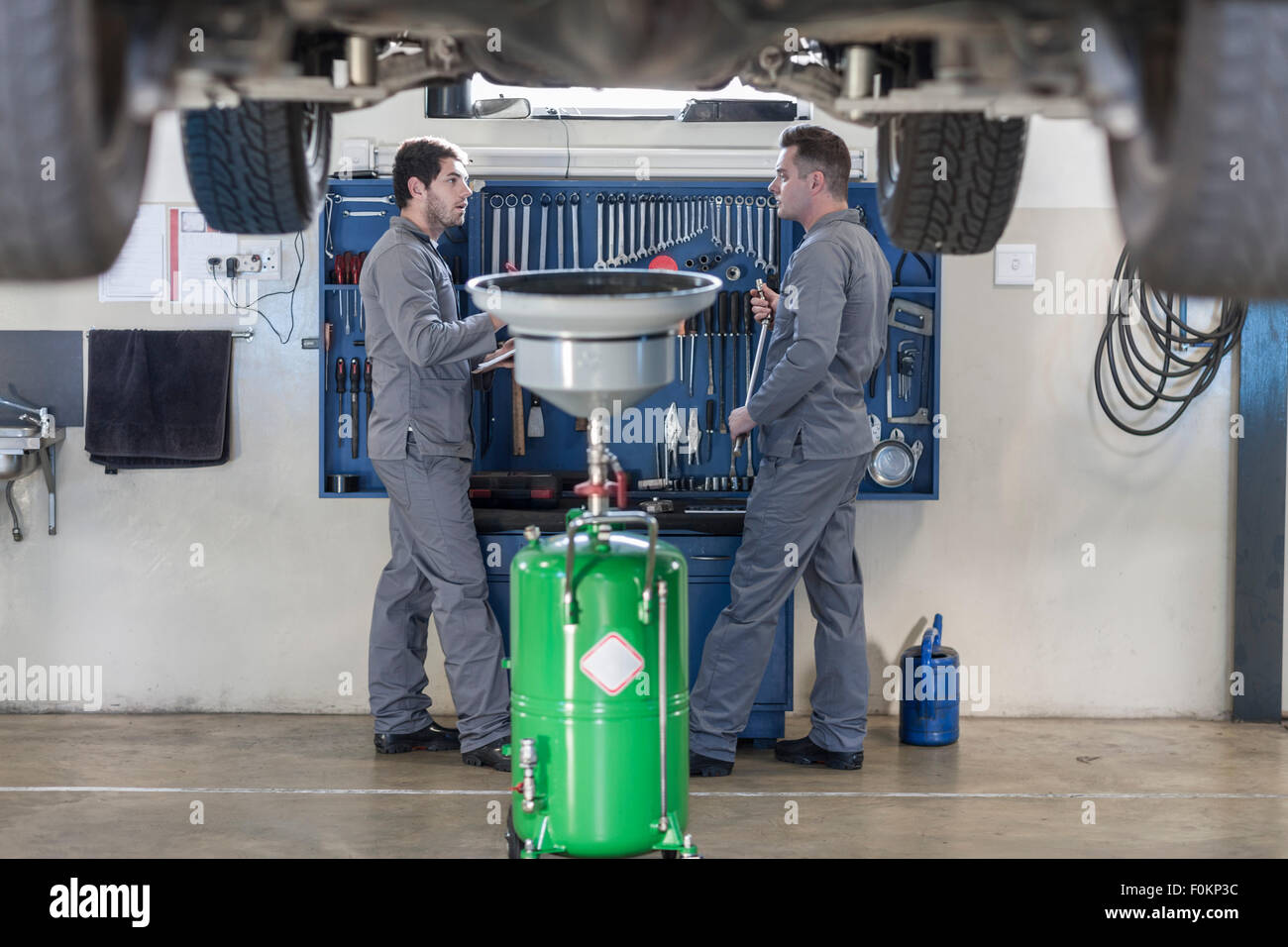 Deux mécaniciens auto au travail dans un garage de réparation Photo ...