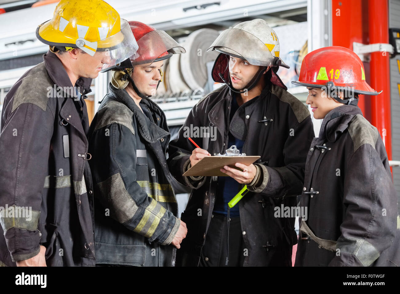 Équipe de pompiers à discuter sur le presse-papiers Photo Stock - Alamy