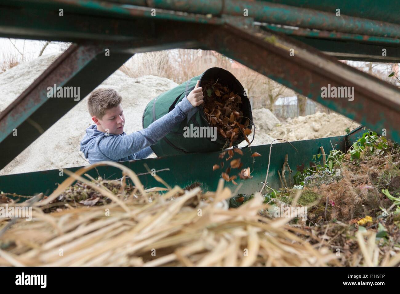 Teenage boy Vider bac de recyclage des déchets de jardin en Photo Stock ...