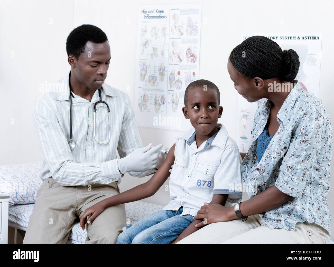 Doctor giving enfant africain une injection dans une chambre du médecin ...
