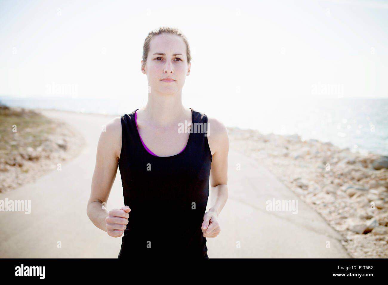 Femme en tenue de sport jogging le chemin au bord de l'eau Photo Stock ...