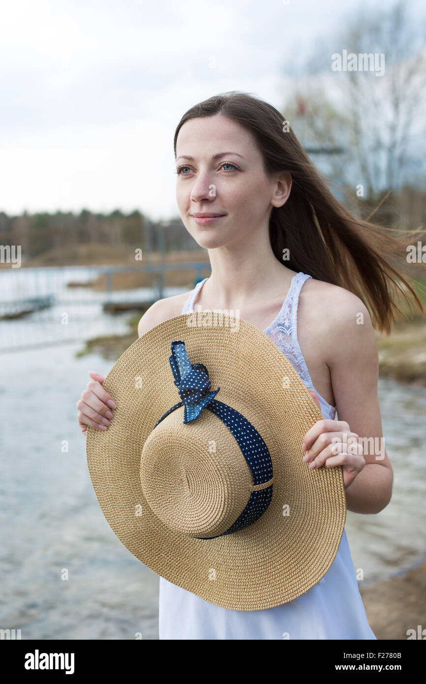 Des taches de rousseur happy girl in white dress holding thatch hat dans ses mains et à la suite ...