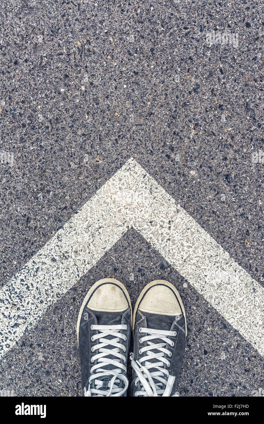 Homme debout au-dessus de la ligne en forme de flèche sur la chaussée ...