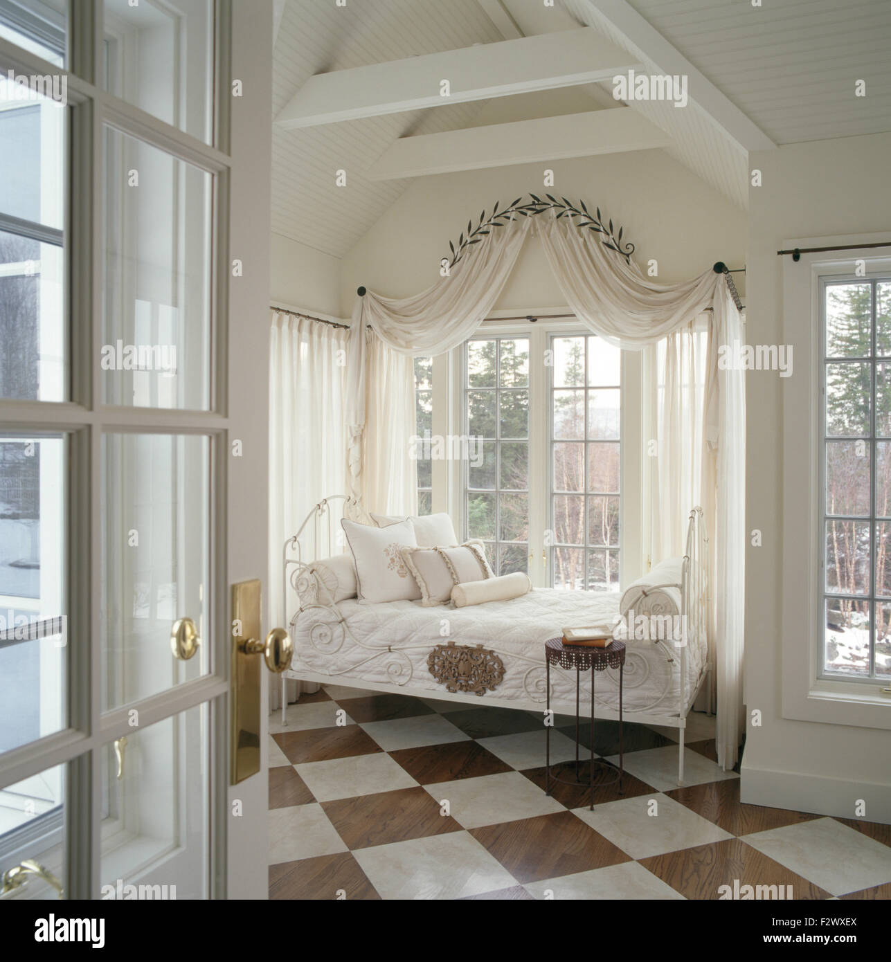 Coronet avec rideaux voile blanc sur windows derrière un lit en fer ...