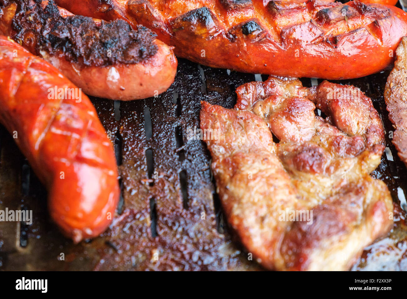 Griller les saucisses sur la grille du barbecue. Focus sélectif Photo ...