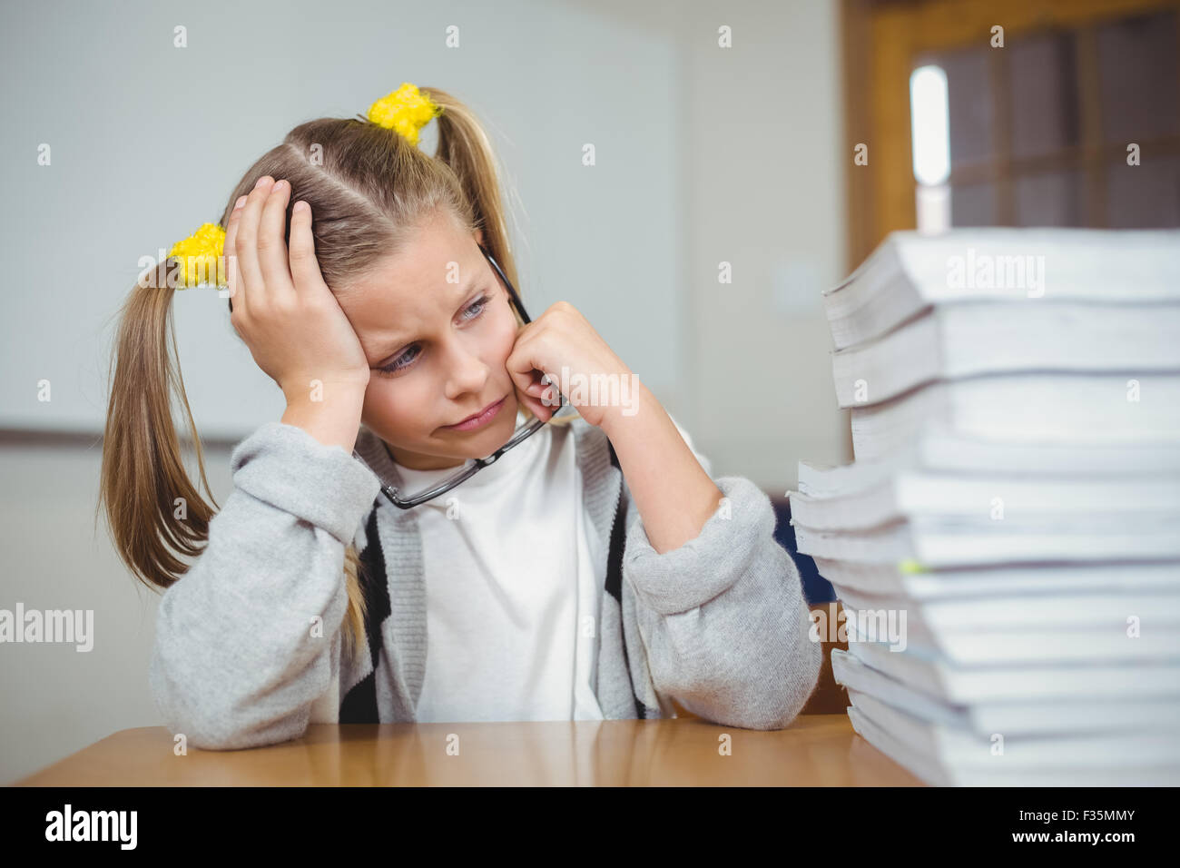Triste élève assise à son bureau dans une salle de classe Photo Stock ...