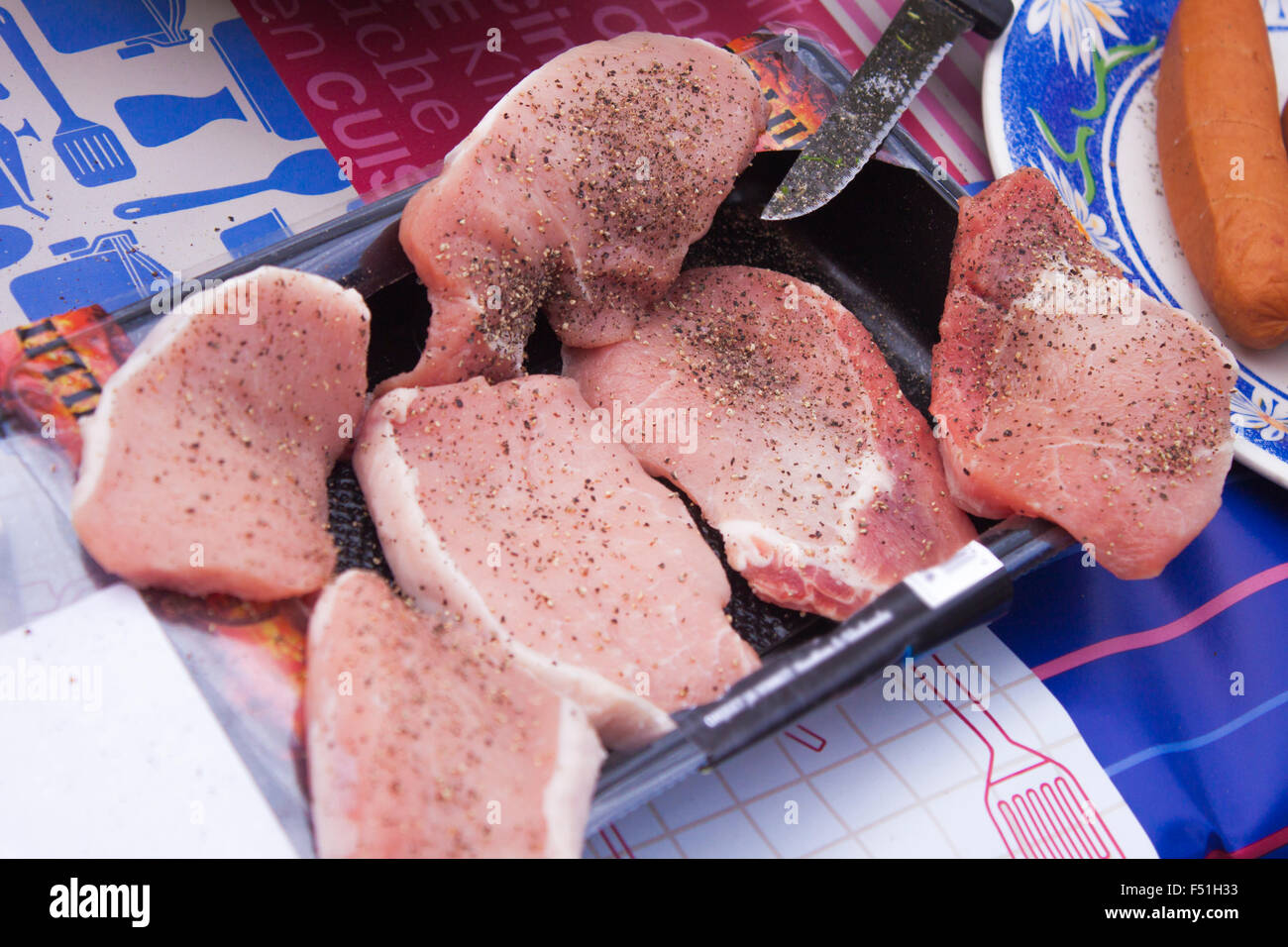 Biftecks de surlonge de porc, sur un tableau coloré, attendant d'être ...