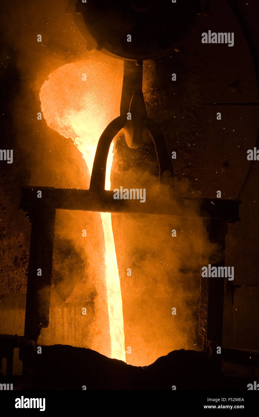 Le fer en fusion s'écoule à partir de la fonderie Pot Photo Stock - Alamy
