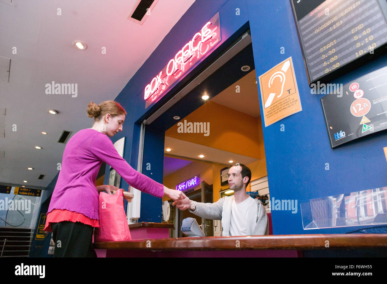 Jeune femme d'acheter un billet pour voir un film dans un cinéma, un ... Jeune femme d'acheter un billet pour voir un film dans un cinéma, un ...