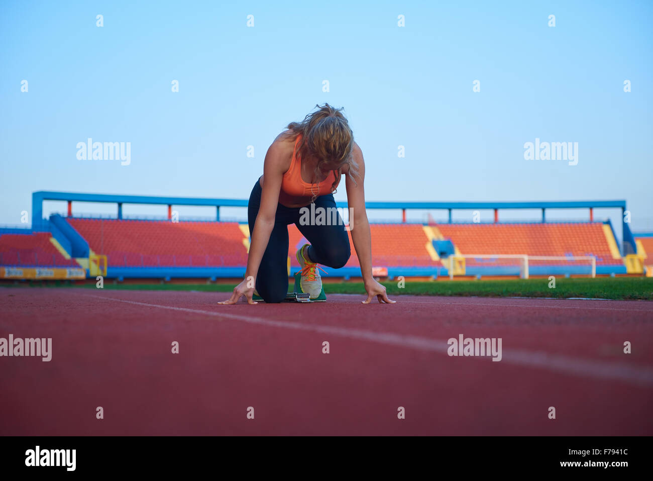 Sprinter femme laissant blocs de départ sur la piste d'athlétisme ...