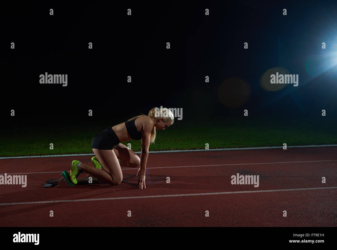 Sprinter femme laissant blocs de départ sur la piste d'athlétisme ...