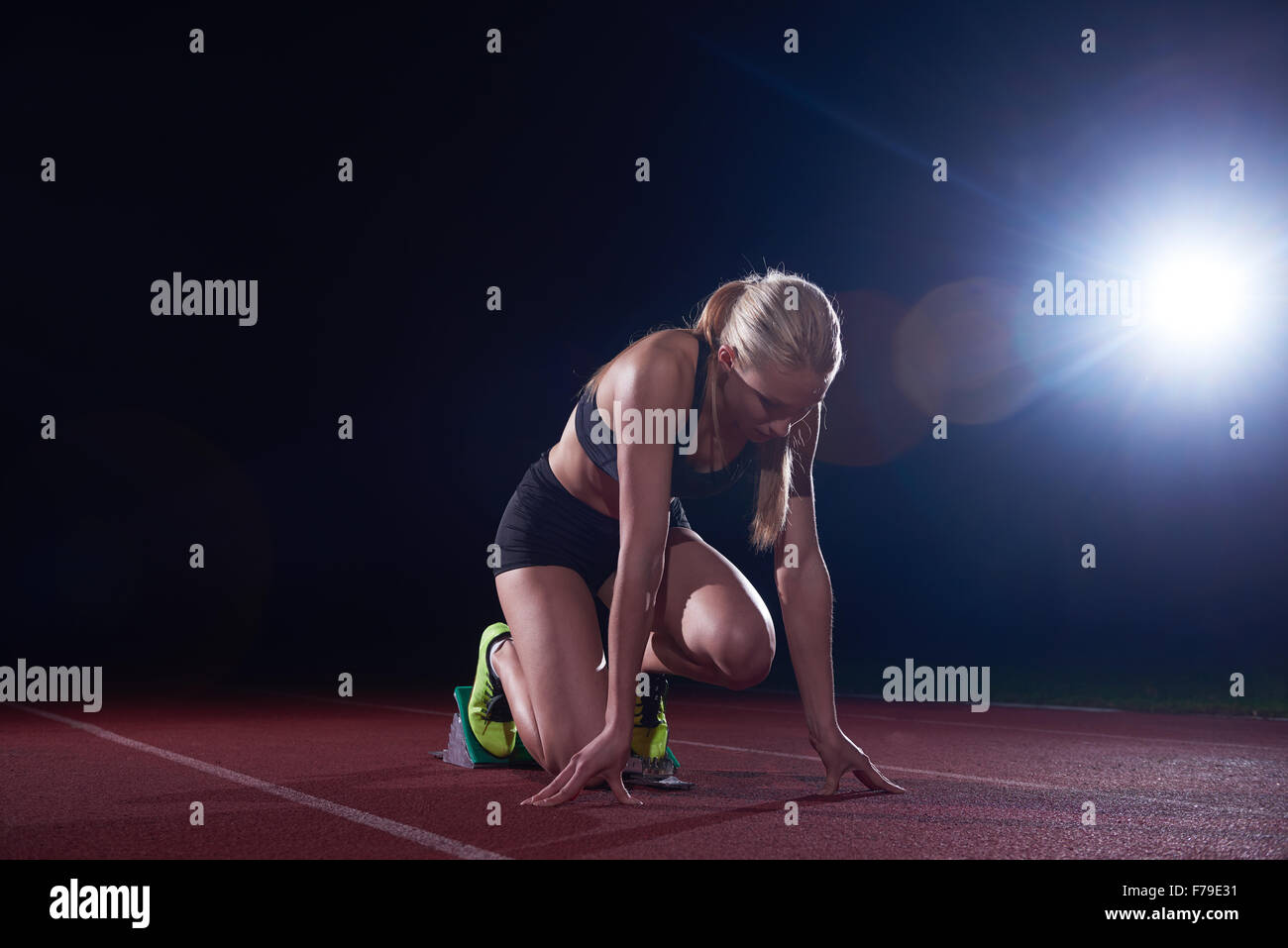 Sprinter femme laissant blocs de départ sur la piste d'athlétisme ...