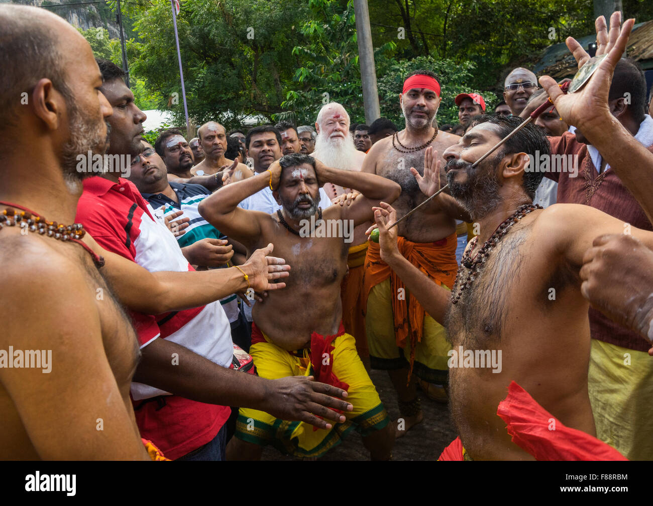 Un dévot joue est percée d'une brochette d'un prêtre à Thaipusam fête hindoue à Batu Caves, en ...