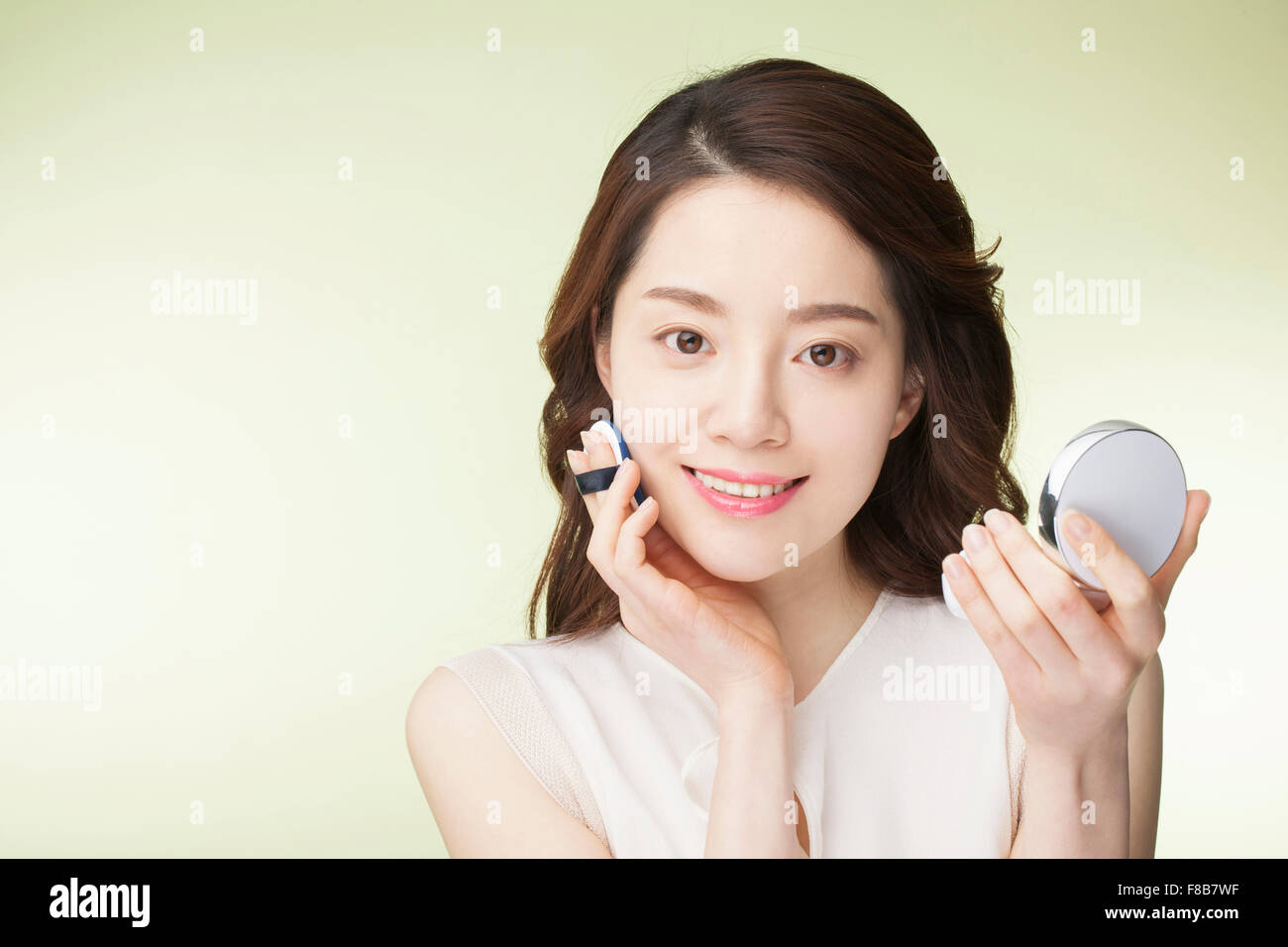 Femme coréenne avec la longue chevelure ondulée en chemise blanche mise ...