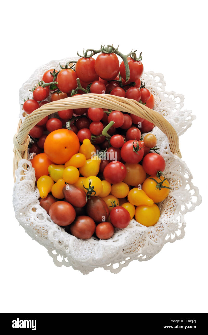 Différentes variétés de tomates dans un panier sur un fond blanc Photo ...