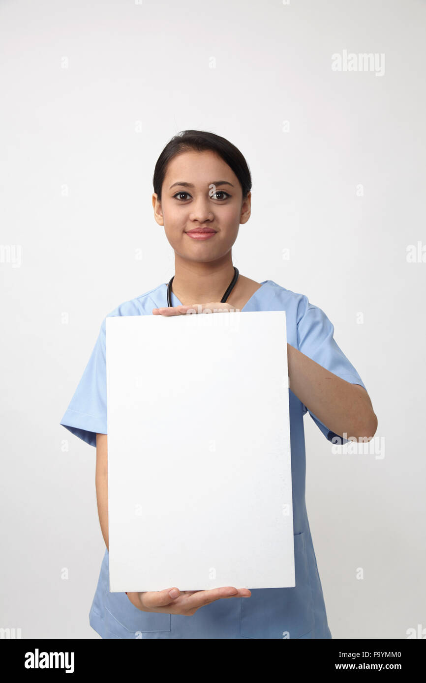 Signe médical Infirmière montrant billboard standing, jeune femme ...