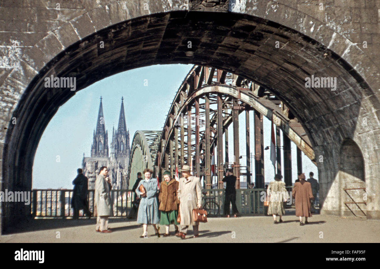 Passanten flanieren Unter dem Brückenportal Hohenzollernbrücke der à ...