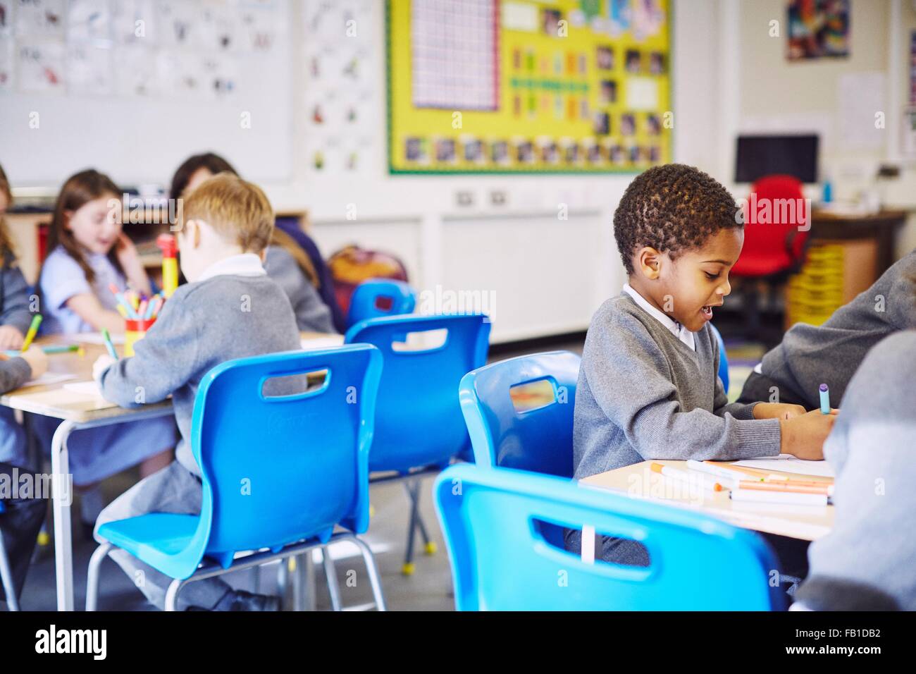 Les enfants dessin à un bureau dans la salle de classe de l'école ...