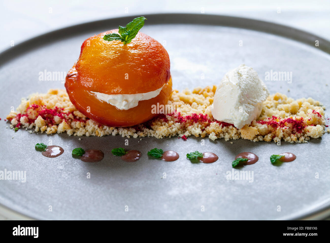 Pêche rôtie à la crème, poudre de framboise et biscuit émietté Photo ...