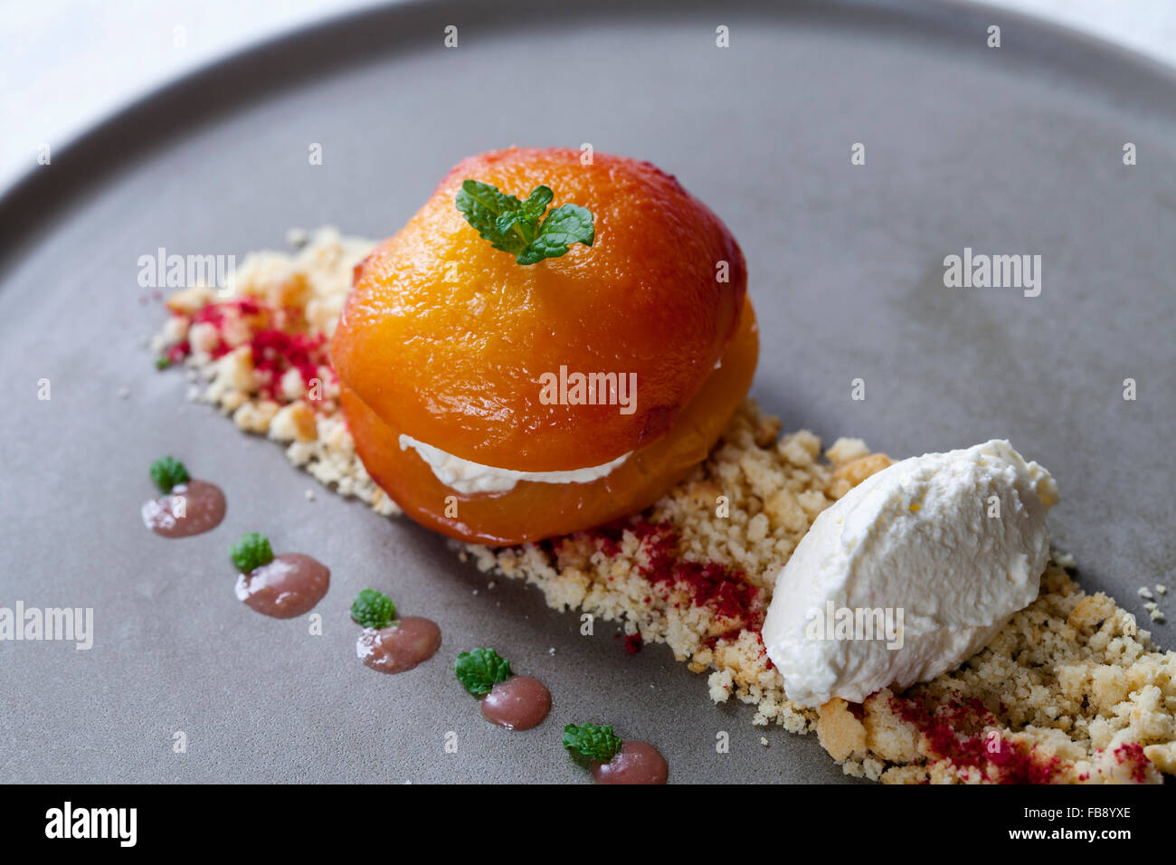 Pêche rôtie à la crème, poudre de framboise et biscuit émietté Photo ...