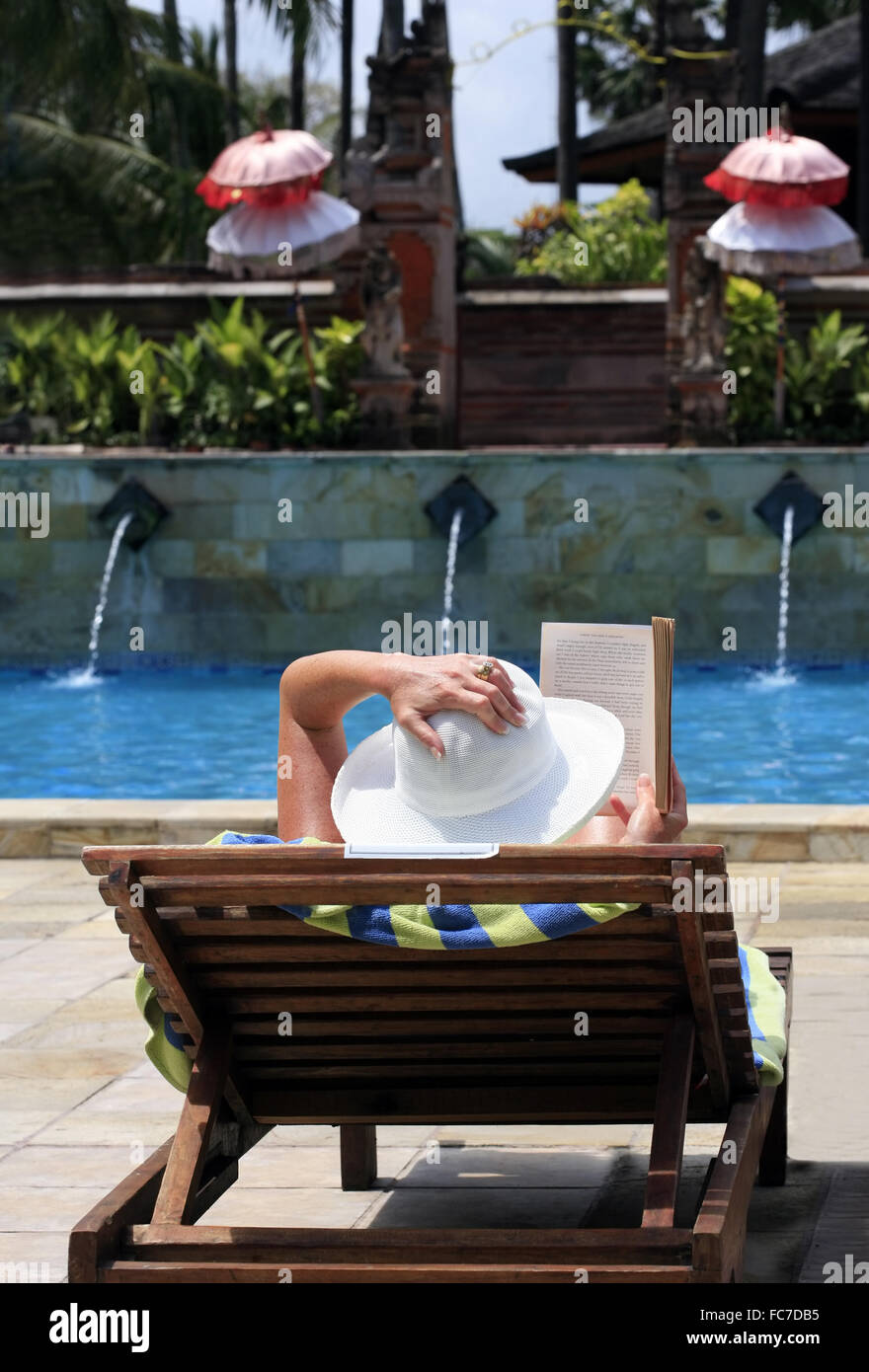 Femme en chaise au bord de la piscine Banque de photographies et d’images à haute résolution - Alamy