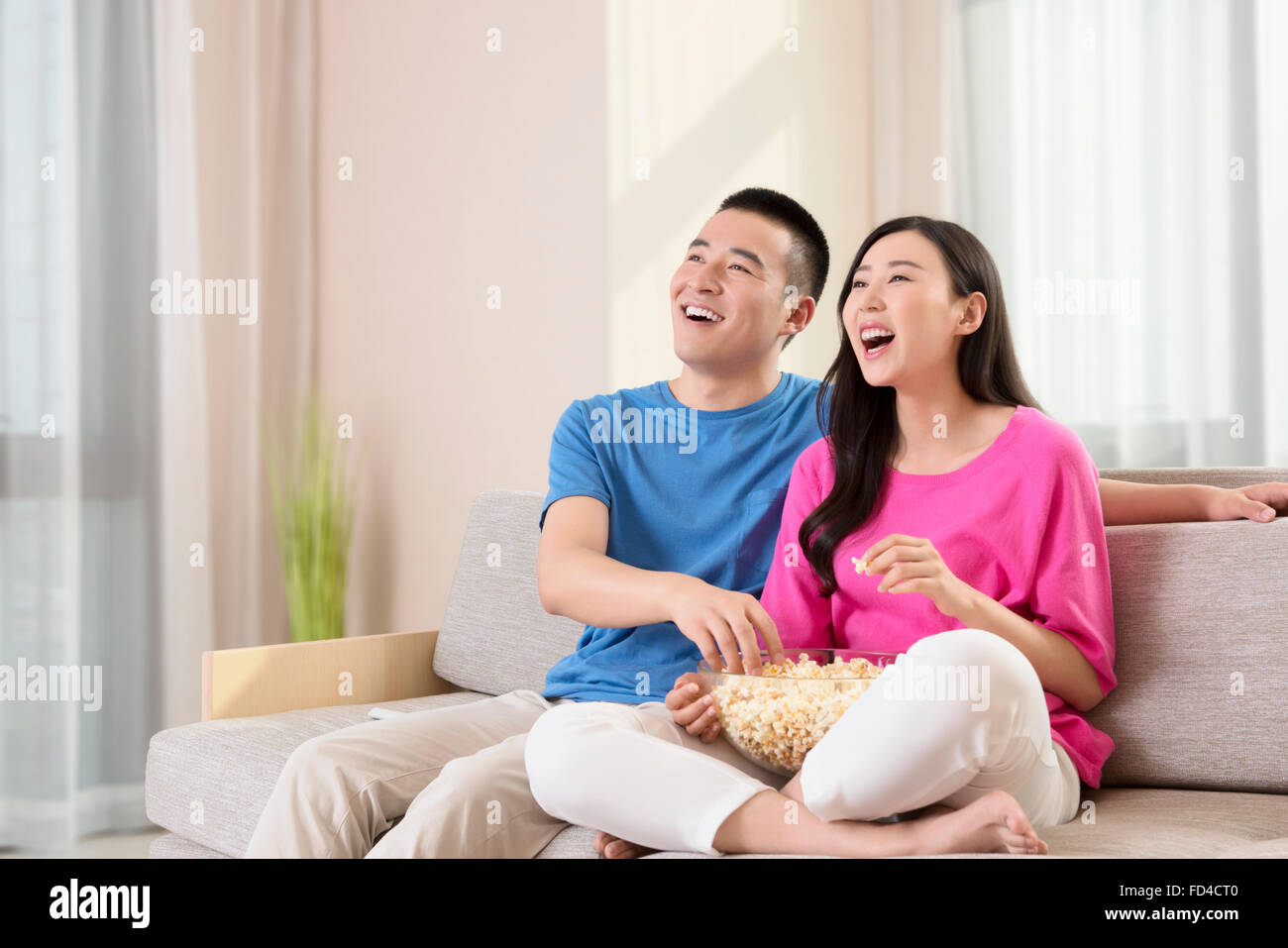 Jeune couple devant la télé Banque de photographies et d’images à haute ...