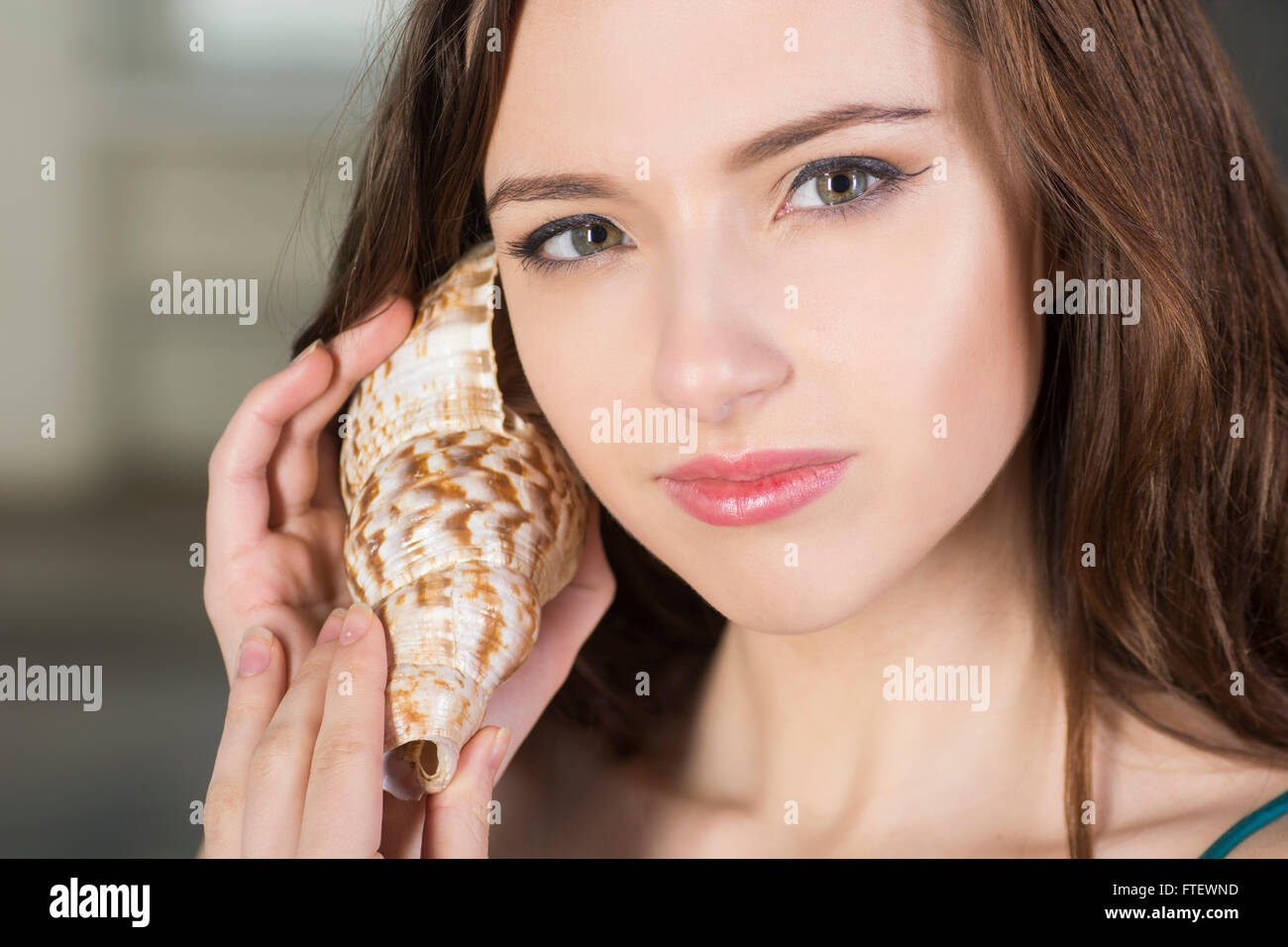 Woman holding seashell to ear Banque de photographies et d’images à ...