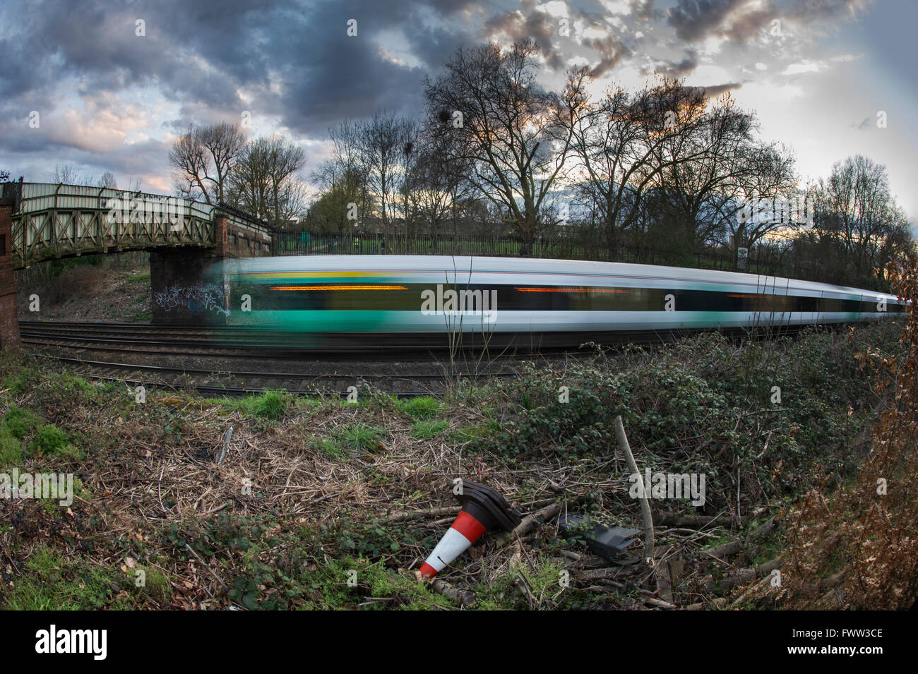 Un train de banlieue clignote passé, certains déchets sur le remblai de ...