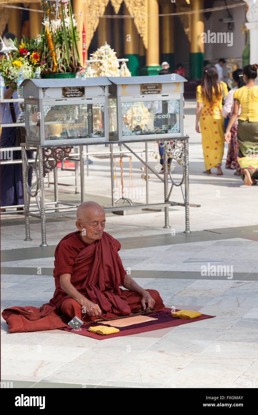Un cross-legged un moine en prière devant une annexe de la Paya ...