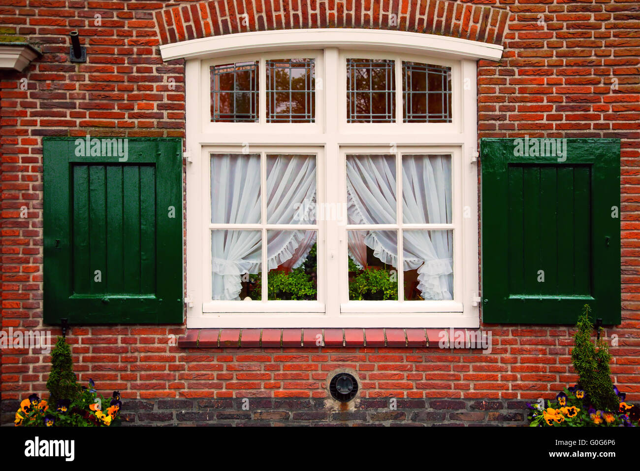 Fenêtre ancienne rétro avec des volets sur la maison en brique rouge ...