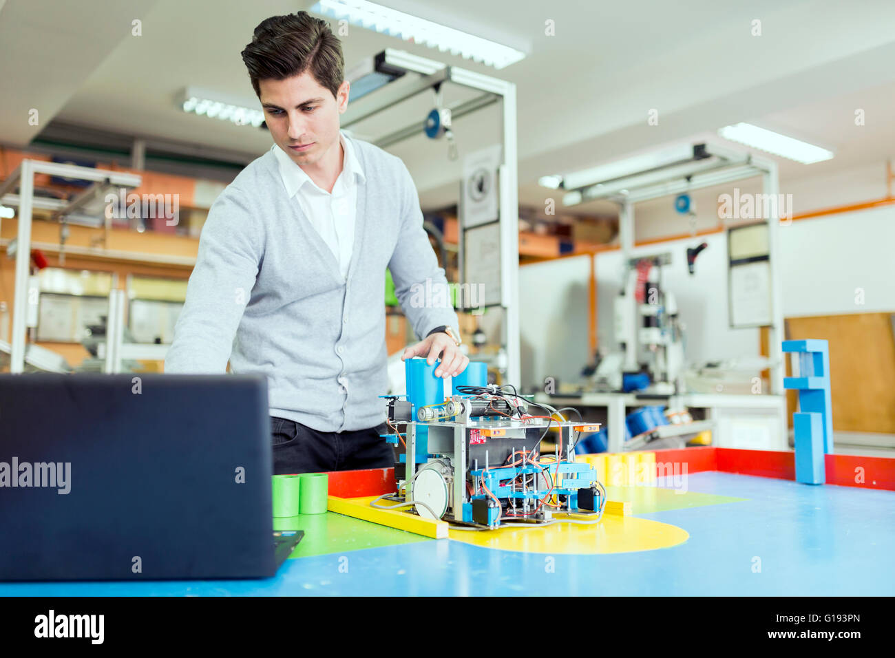 Ingénieur électrique mâle de la programmation d'un robot à la classe de ...