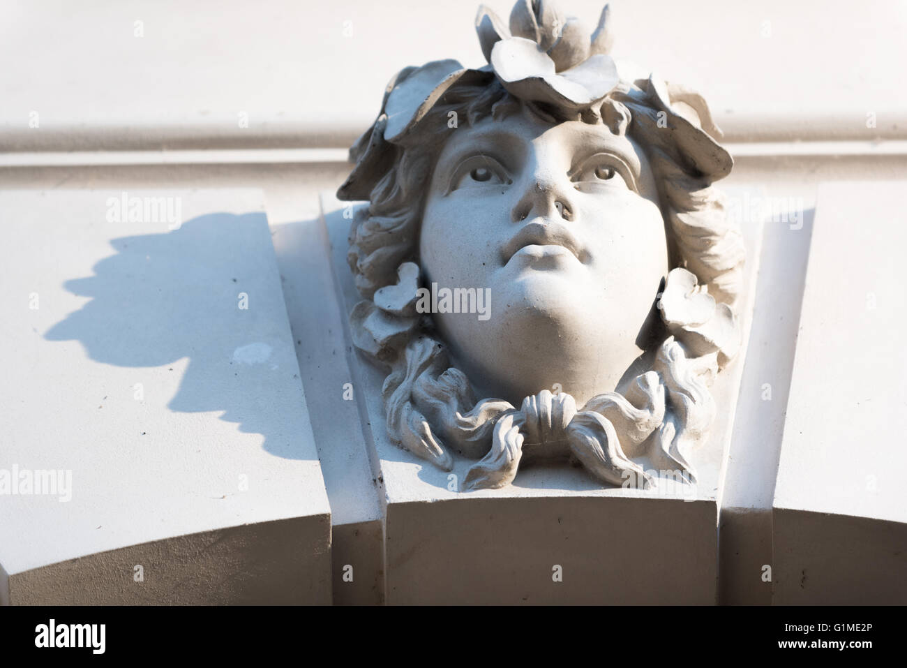 Figure de pierre face avec son ombre projetée sur la façade Photo Stock ...