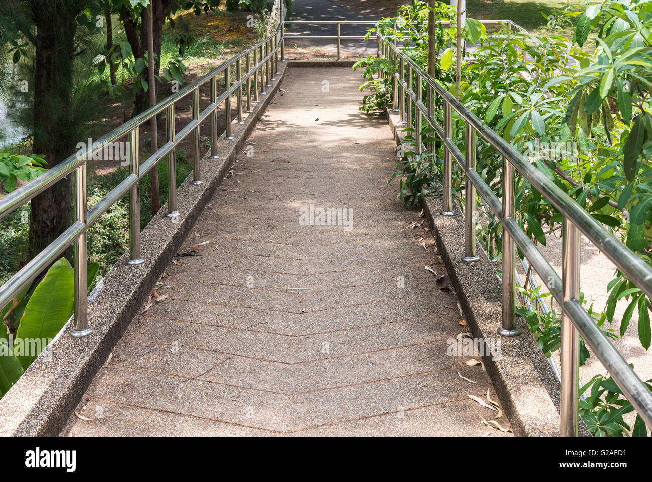 Pont passerelle moderne avec garde-corps en métal dans le parc urbain ...