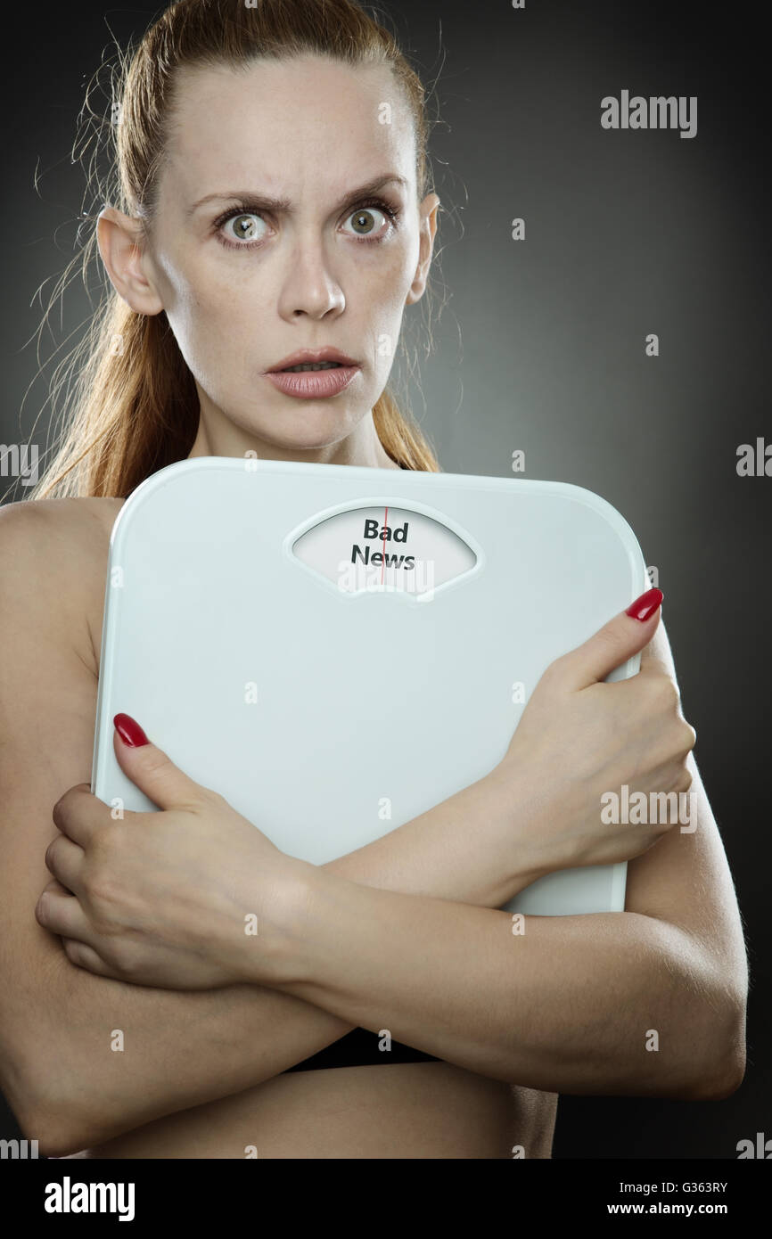 Femme tourné en studio, l'éclairage à faible clés poids holding évolue ...