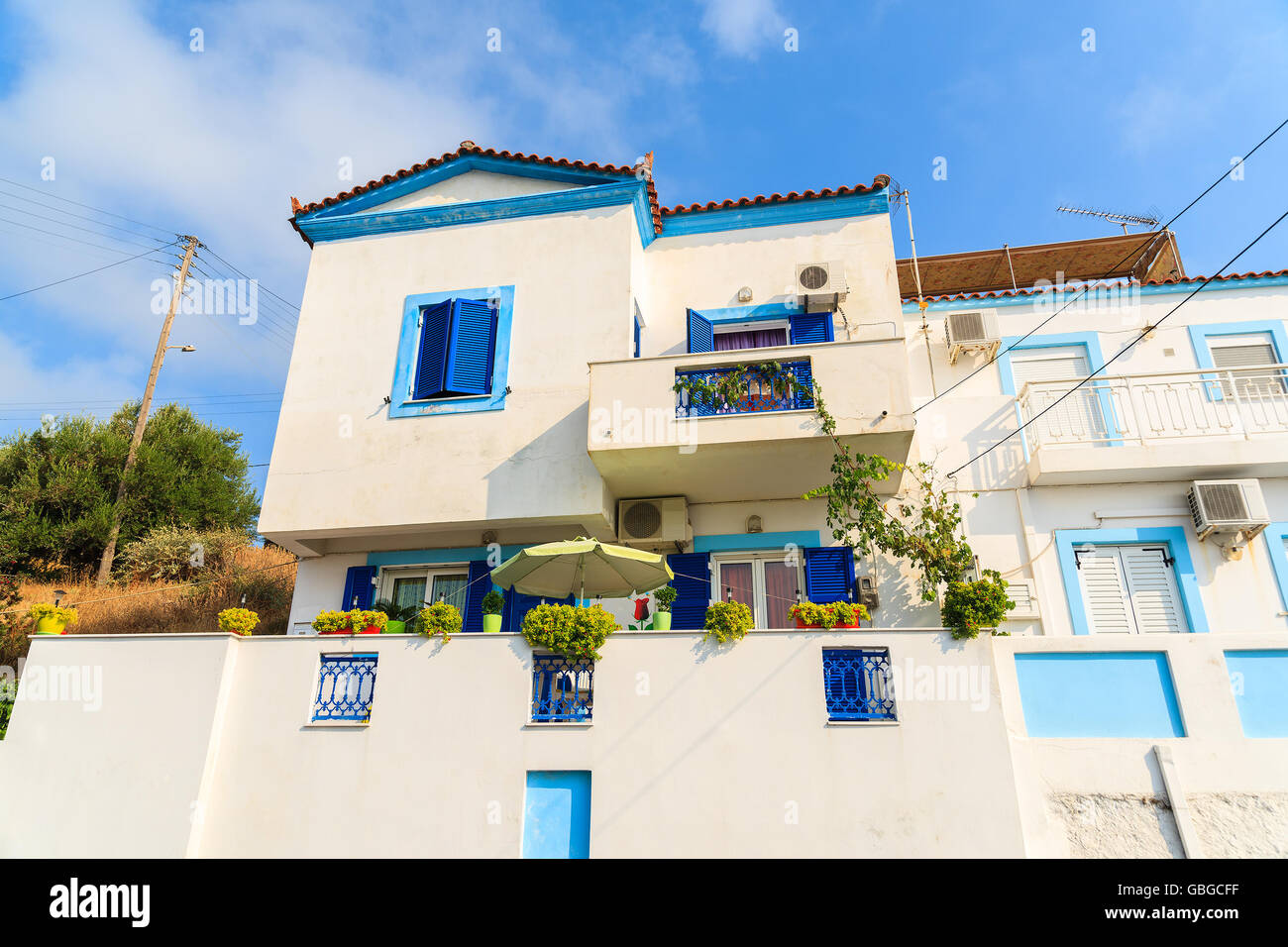 Maison typique grec blanc aux volets bleus sur la côte de l'île de ...