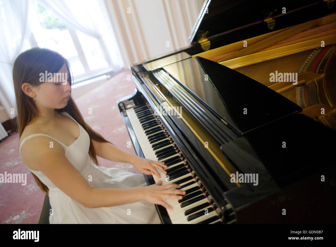Femme en robe blanche jouant un grand piano Photo Stock - Alamy