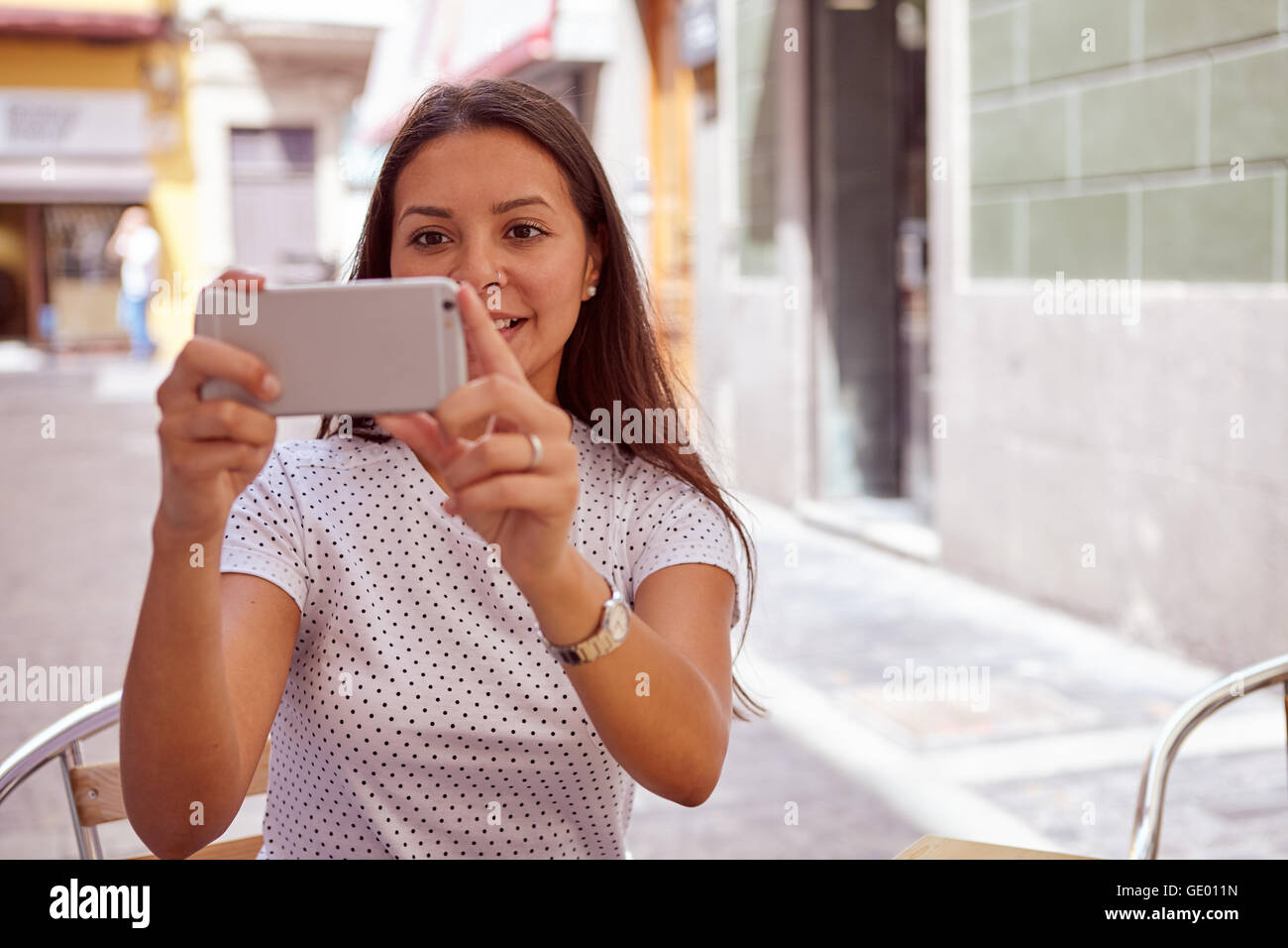Heureusement smiling young girl dans un café de la rue prendre des ...