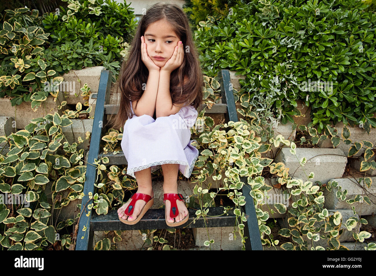 Little girl sitting on steps Banque de photographies et d’images à haute résolution - Alamy