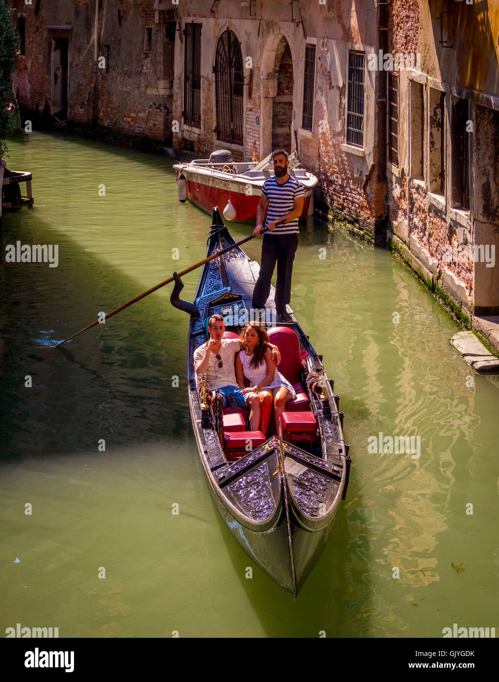 Gondolier vêtu du costume traditionnel haut rayé sa direction le long d ...