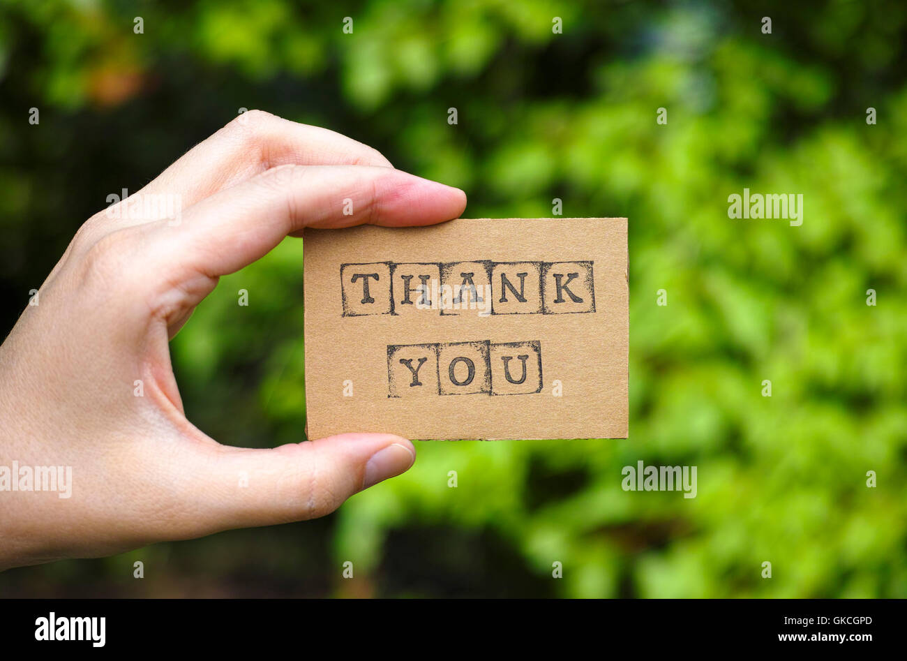 Femme main tenant la carte en carton avec des mots Merci faites par ...