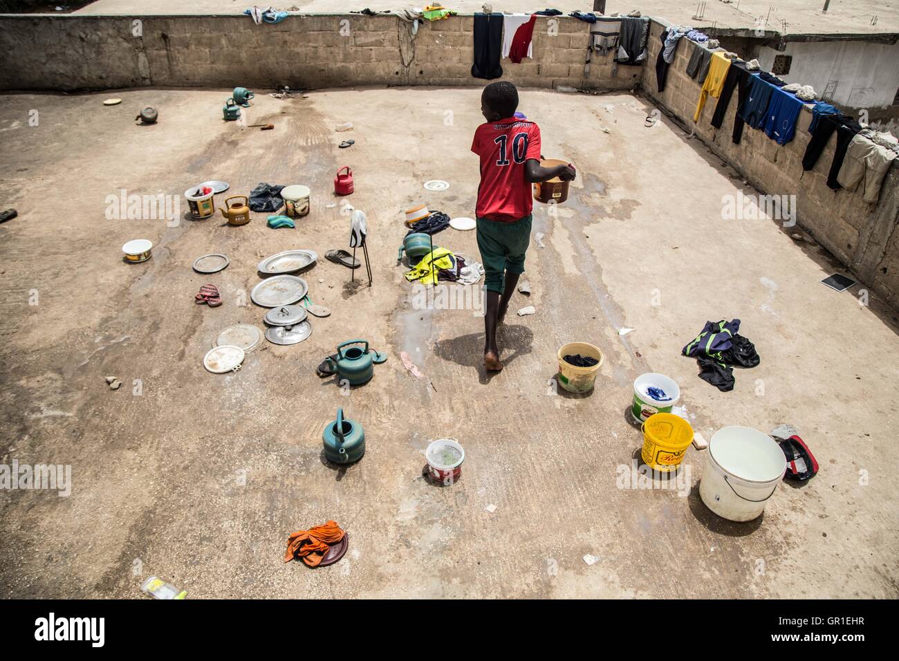 Dakar, Sénégal. 25 Juin, 2015. Un enfant se lave des vêtements sur la ...