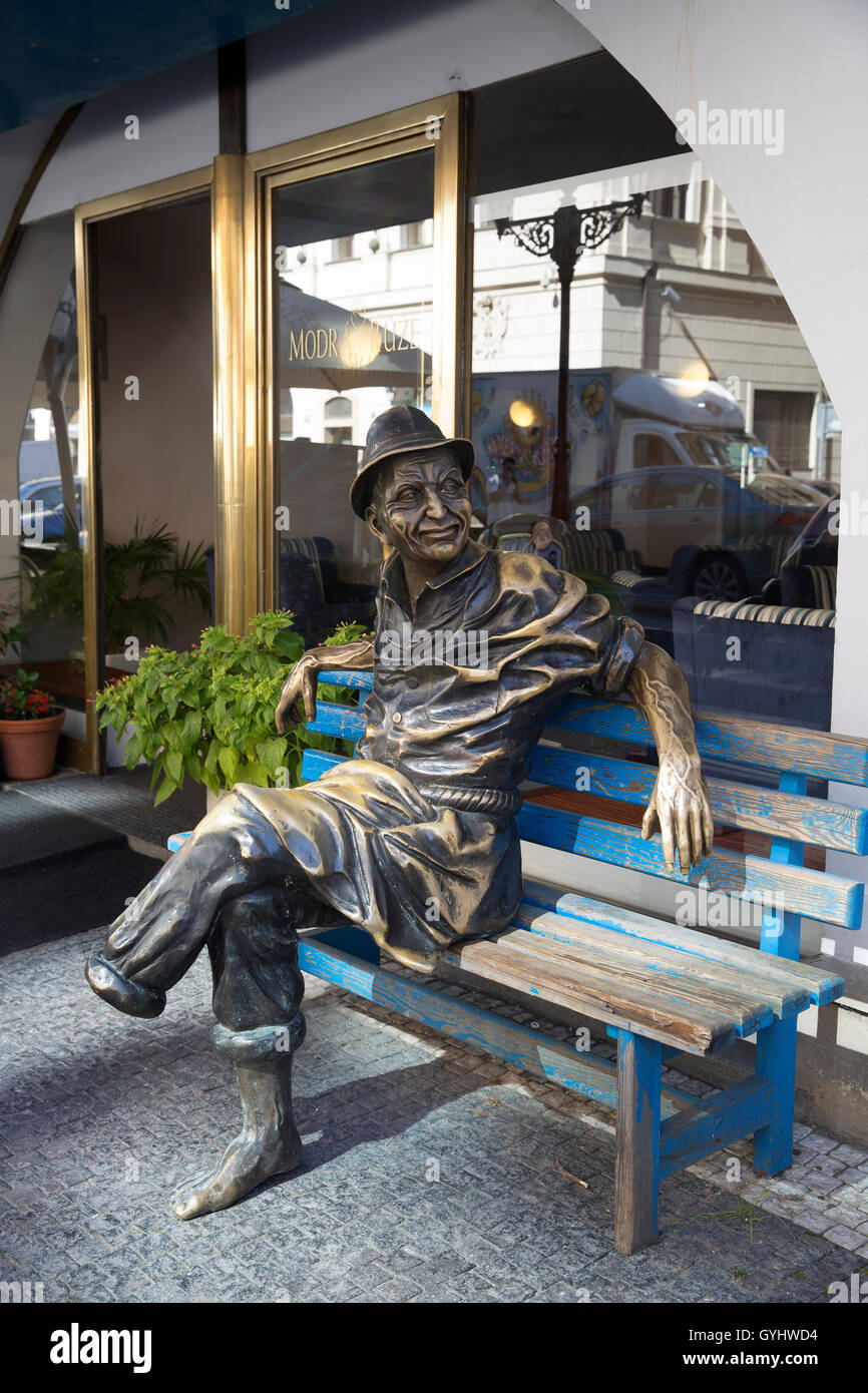 Statue en bronze d'un homme assis sur un banc en bois à Prague Photo ...
